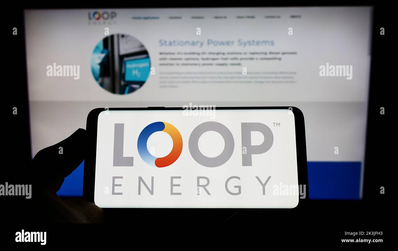 Person holding cellphone with logo of Canadian hydrogen company Loop ...