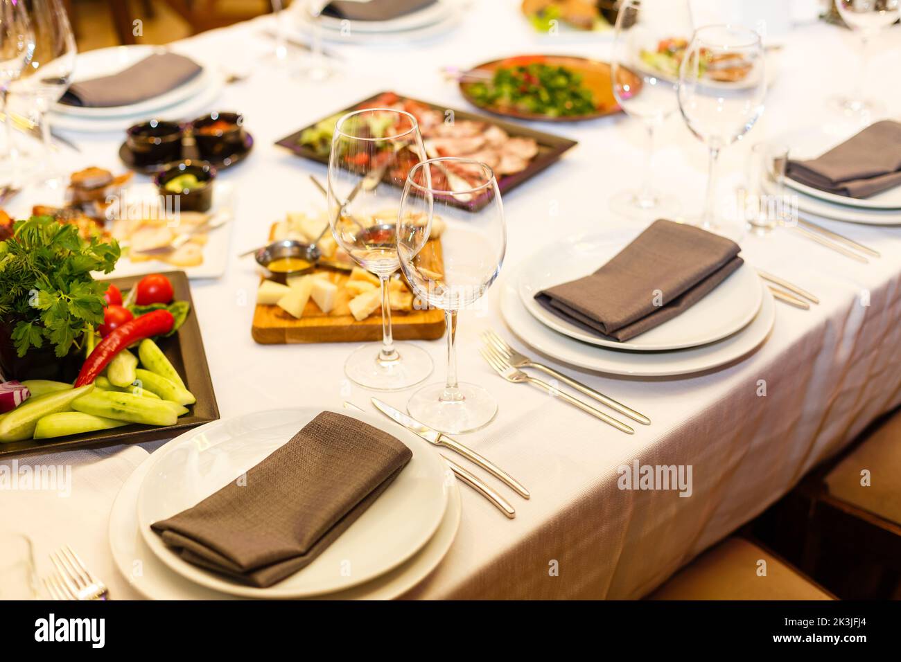 Restaurant table served with assortment of meals. Plate with vegetables ...