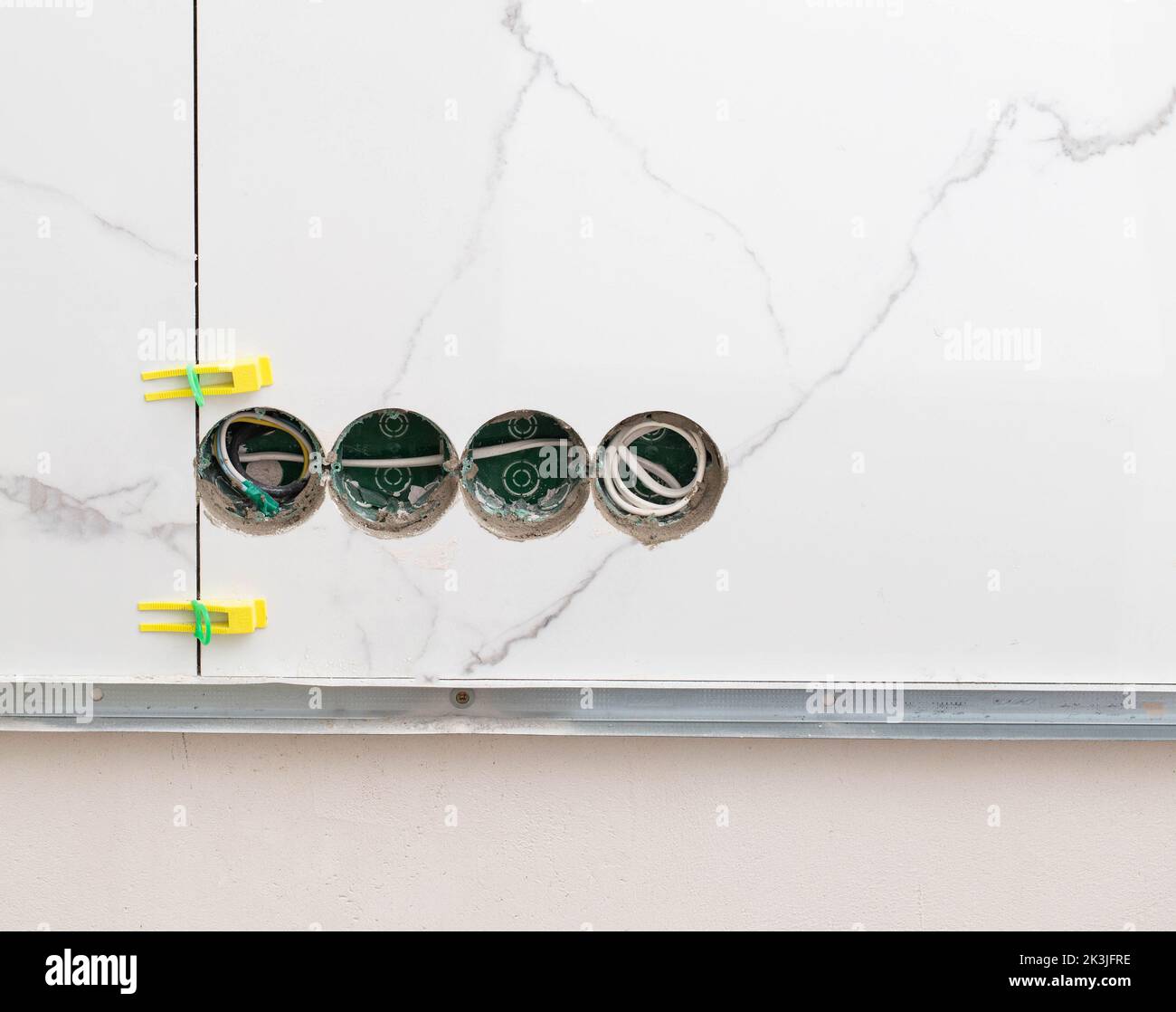 Drilled holes in porcelain stoneware tiles under the socket Stock Photo ...