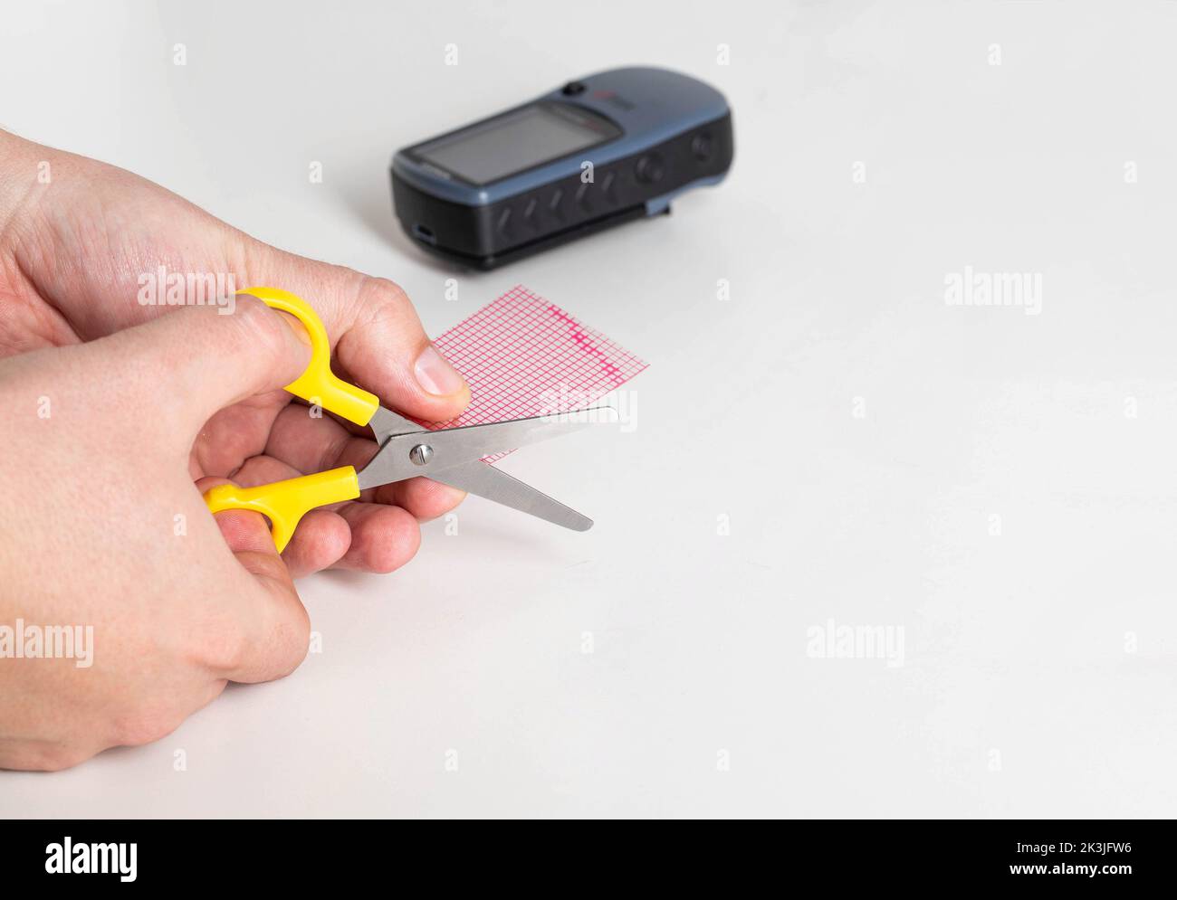 A man cuts off the required size of a protective film with scissors for ...