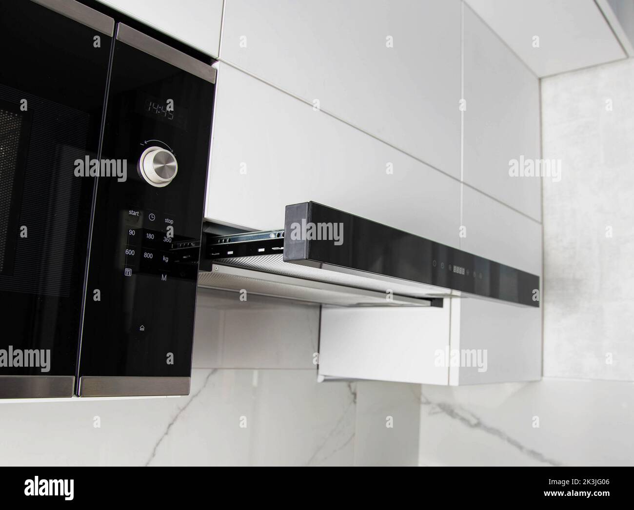 Modern household kitchen appliances. Black retractable telescopic hood ...