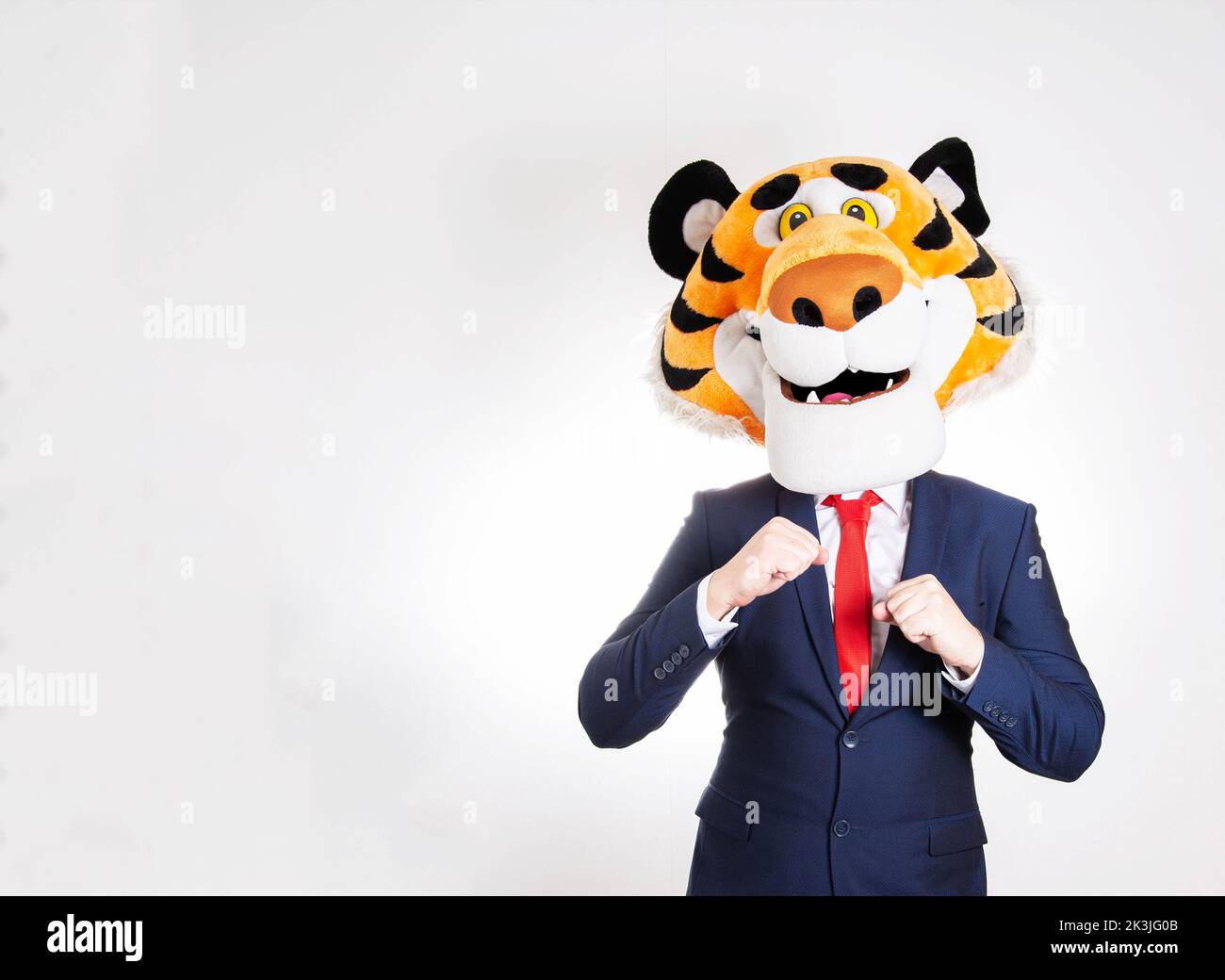 Dancing man in a business suit and a tiger mask on his head on a white ...