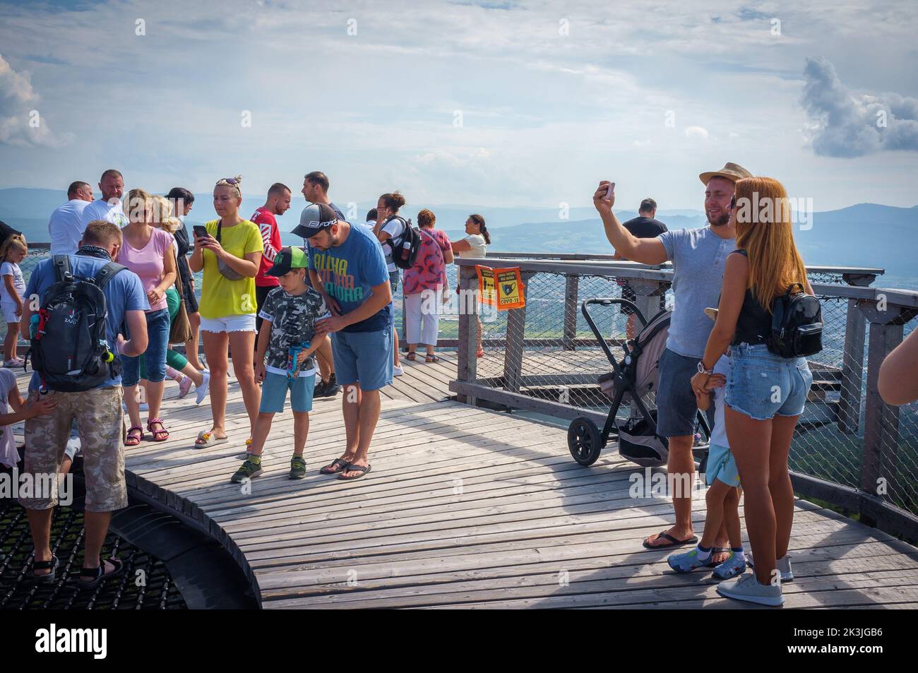 A crowd of tourists walking on the treetop walkway in Bojnice, Slovakia ...