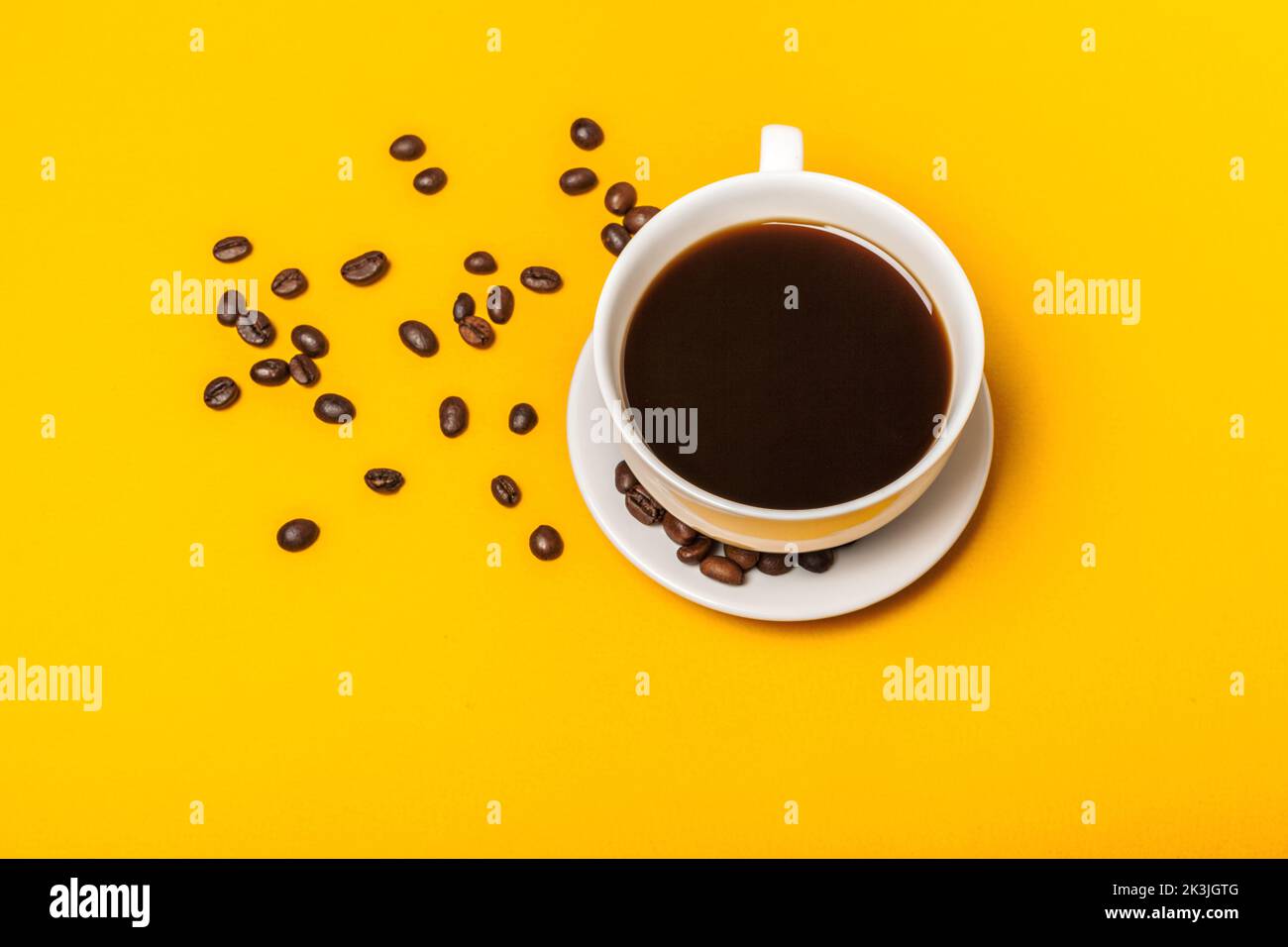 Spilled coffee beans on a bright yellow background Stock Photo - Alamy