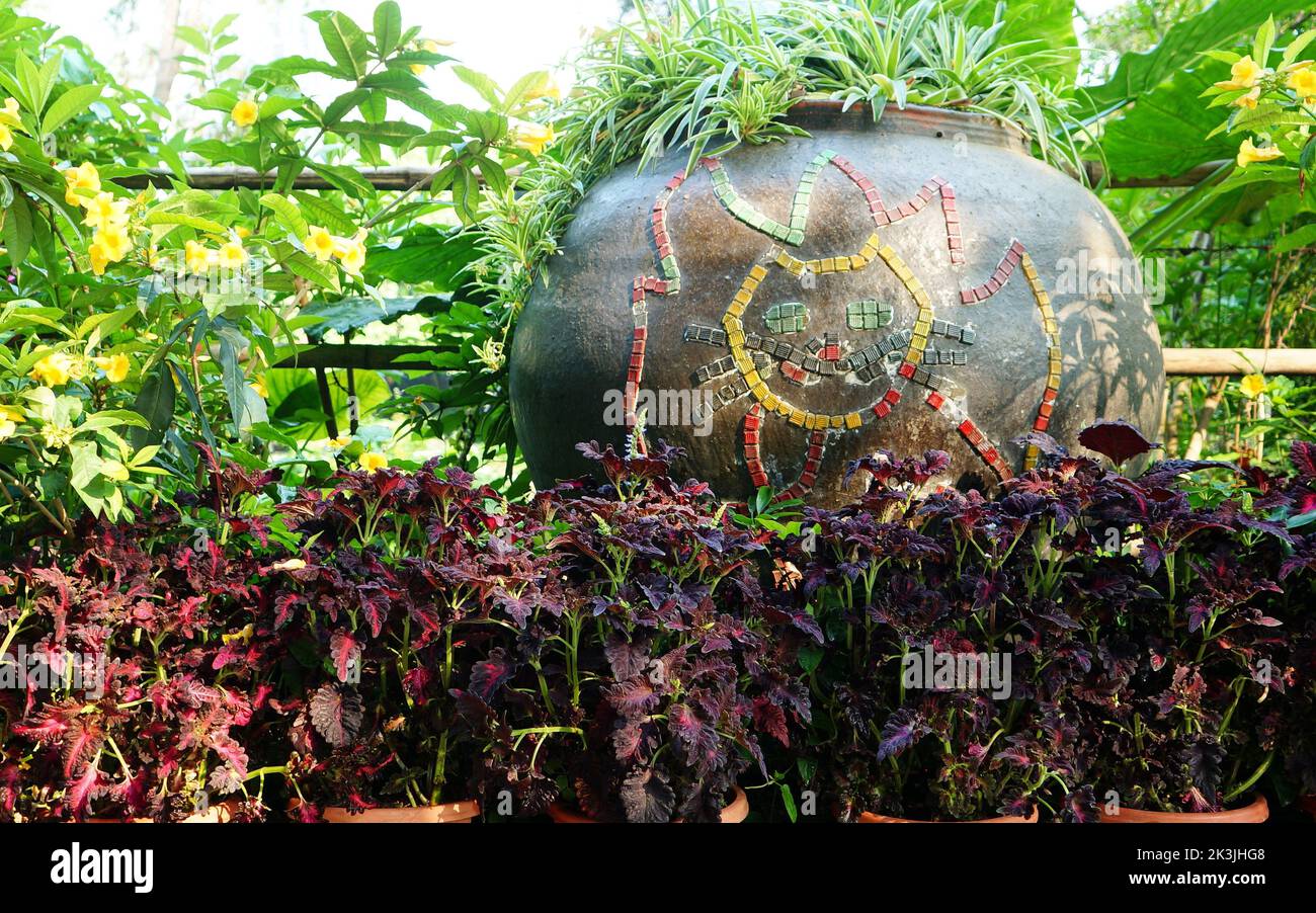 A huge jar in the garden with a cat's face on it Stock Photo - Alamy