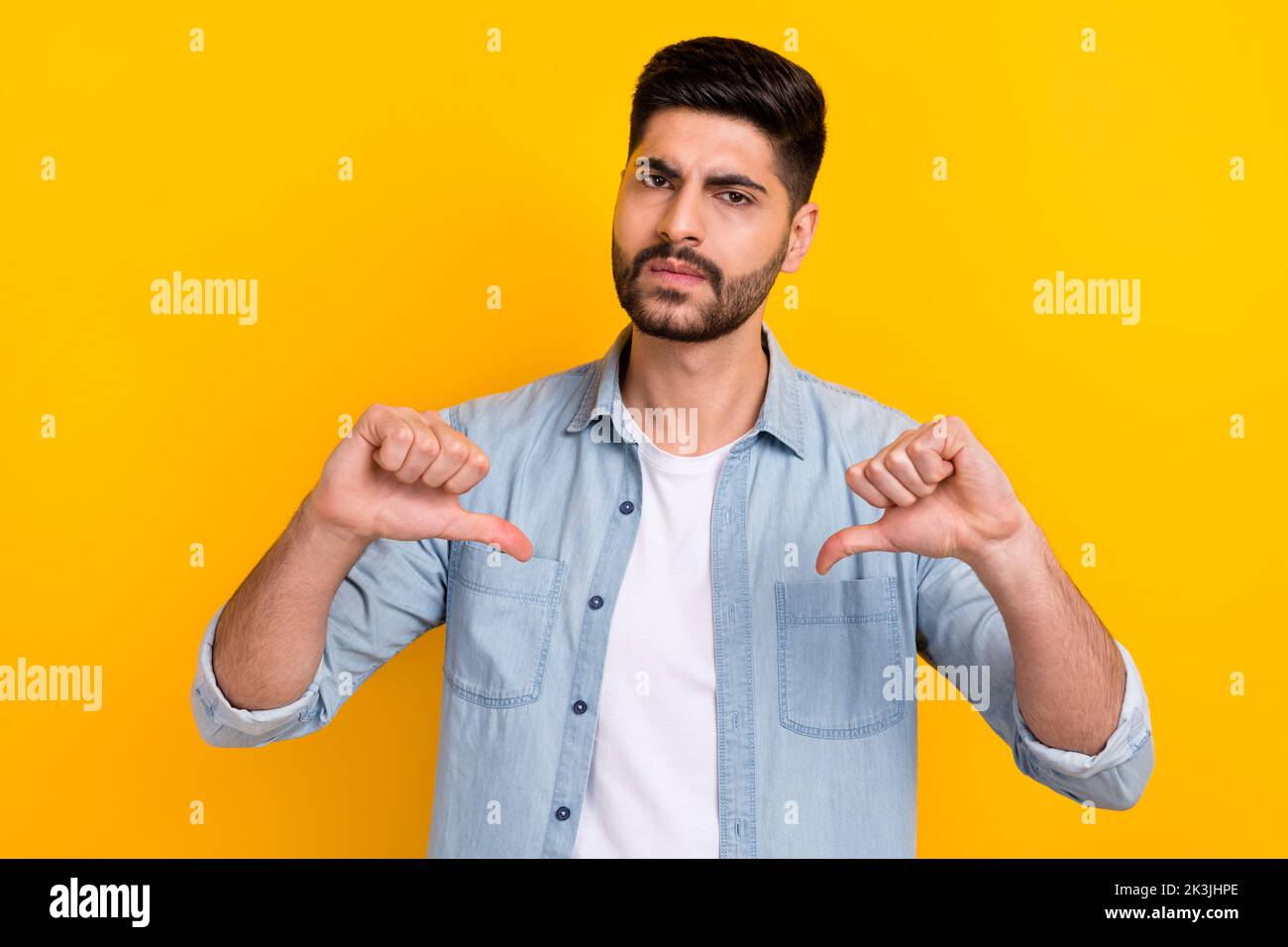 Photo of sad young man wear denim shirt showing two thumbs down ...