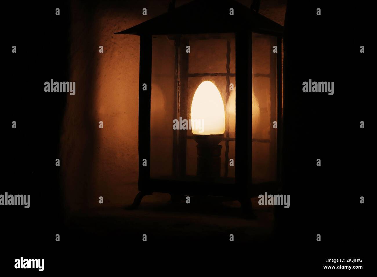Vintage steel lantern with an electric light bulb in the wall niche ...