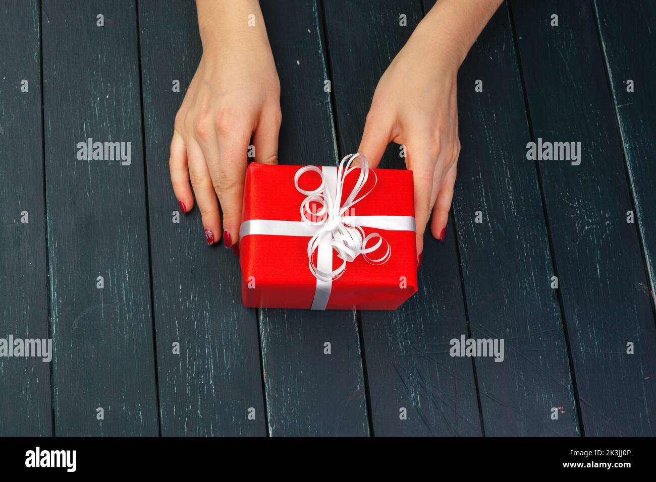 gift box in hand girls on wood table Stock Photo - Alamy