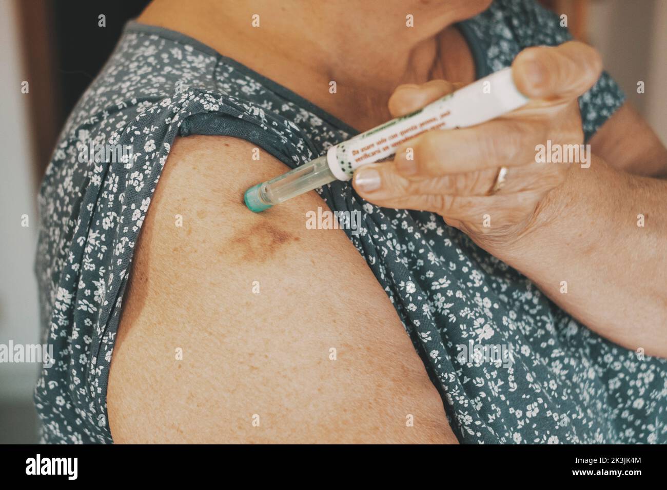 Close up of woman arm with insulin pen. Mature lady injecting diabetes ...