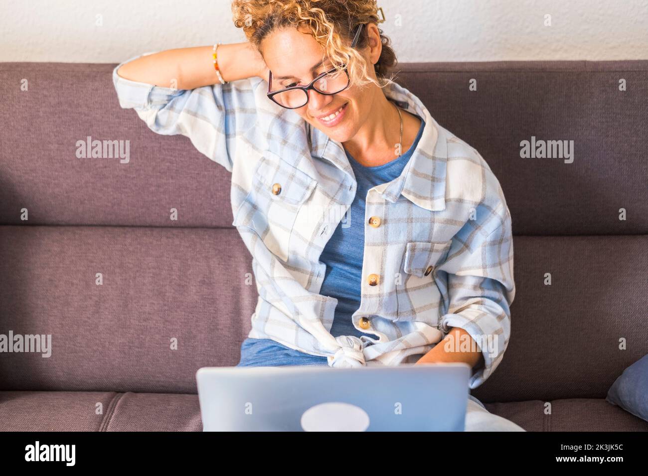 One young woman at home using laptop computer and smiling at the ...