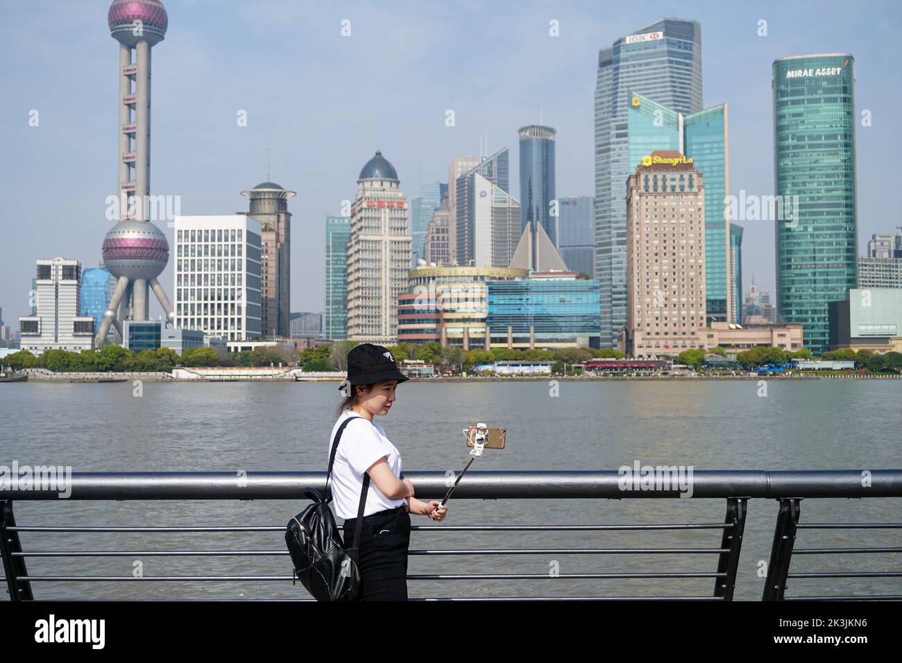 Girl with smartphone on selfie stick taking selfie photo Stock Photo ...