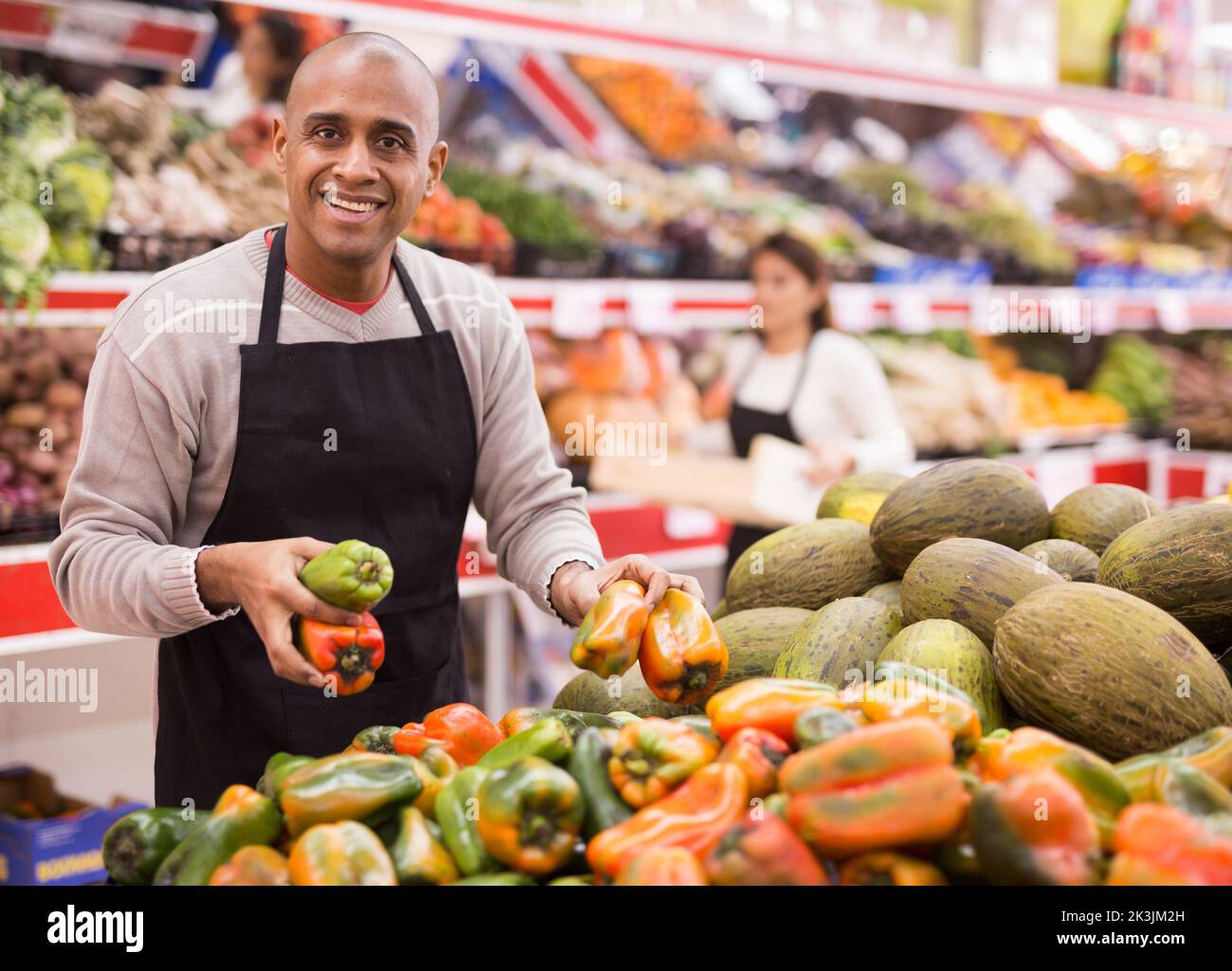 Man working in supermarket near vegetable section Stock Photo - Alamy