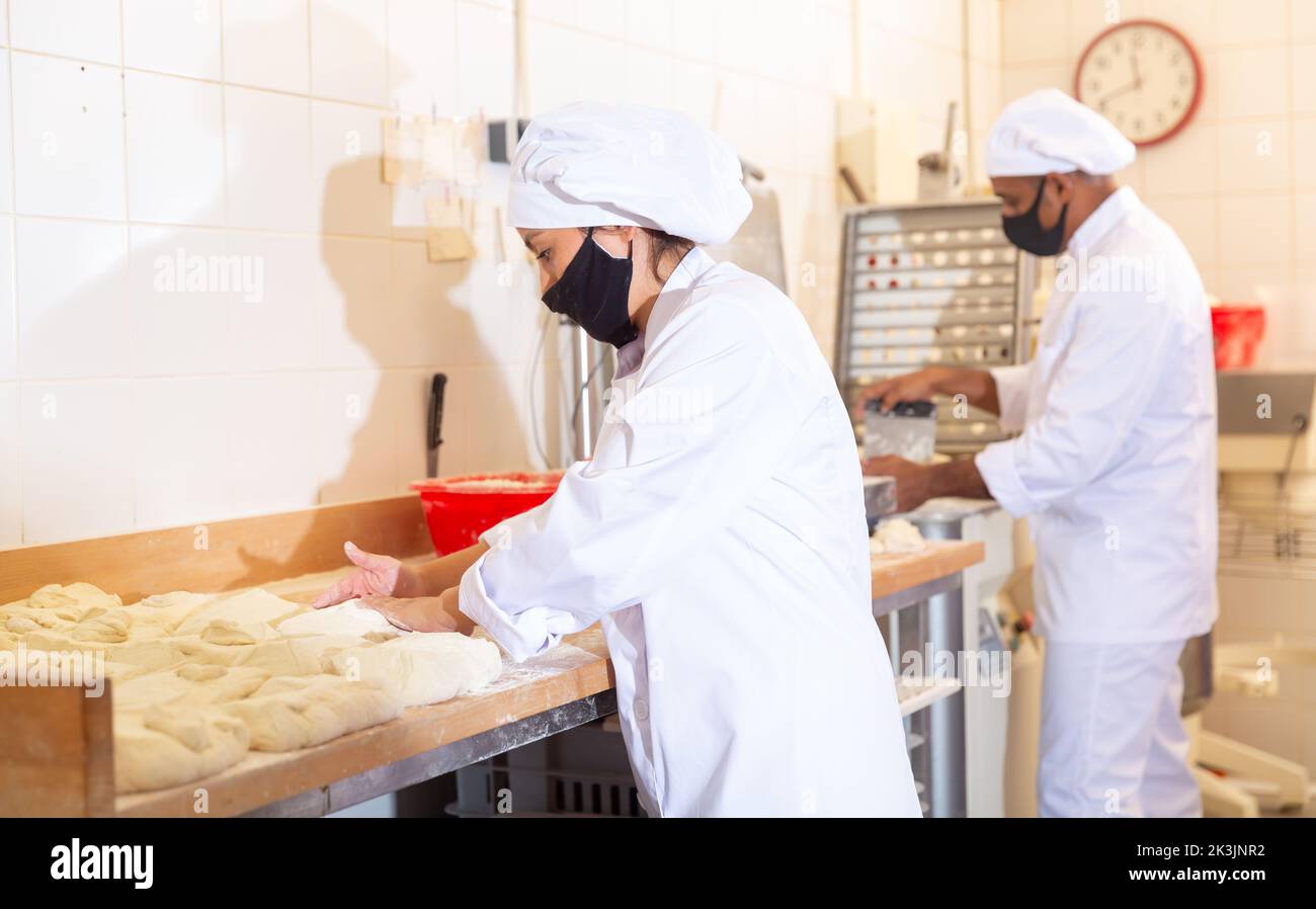 Female baker forming bread loaves from raw dough Stock Photo - Alamy