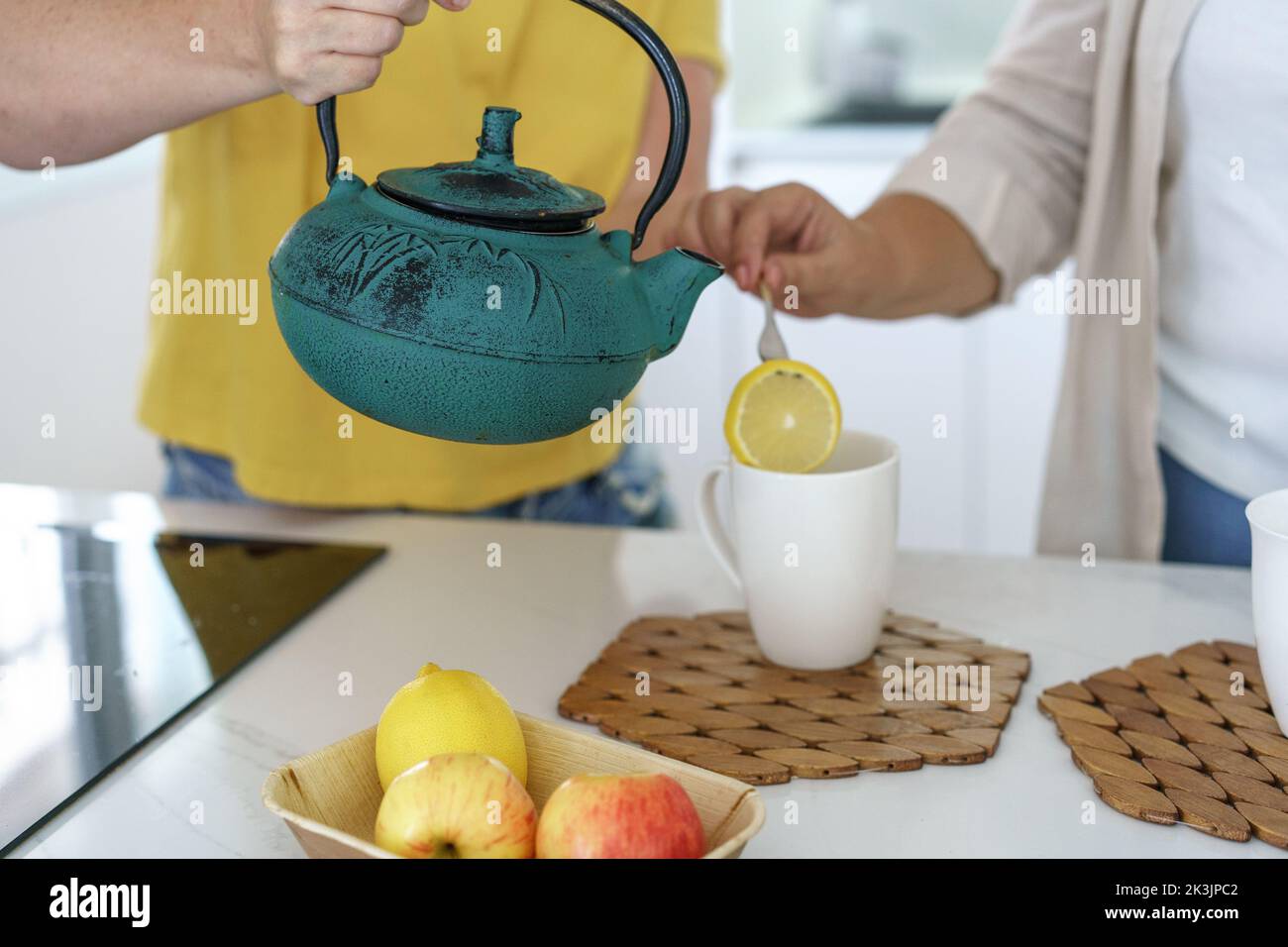 Friends drink tea with lemon. Close up focus on female hand holding ...