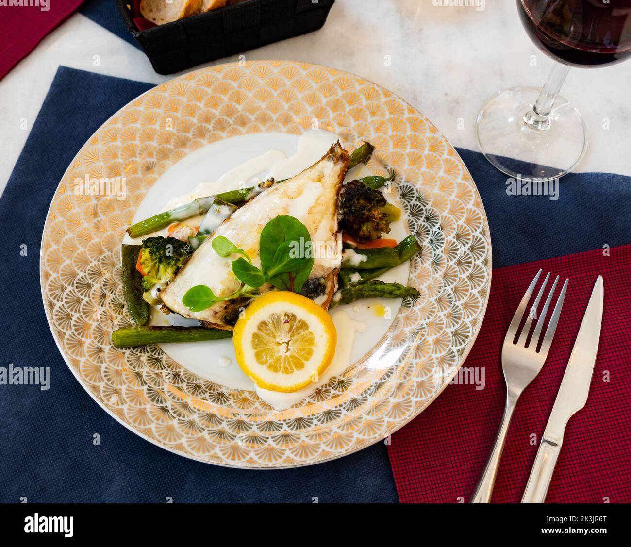 Baked dorada fillet with vegetable garnish and creamy sauce Stock Photo ...