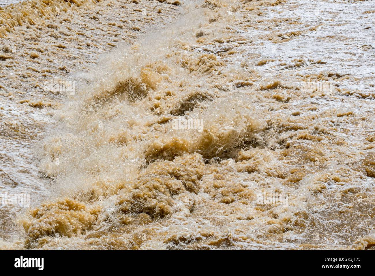 Rapids on the river of muddy water streams flowing and splashing after ...