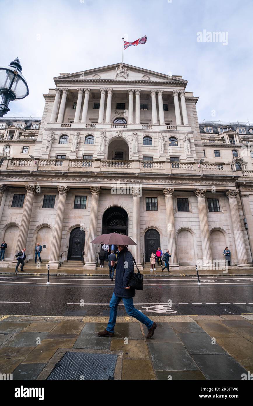 London UK. 27 September 2022 A pedestrian walks with an umbrella past ...