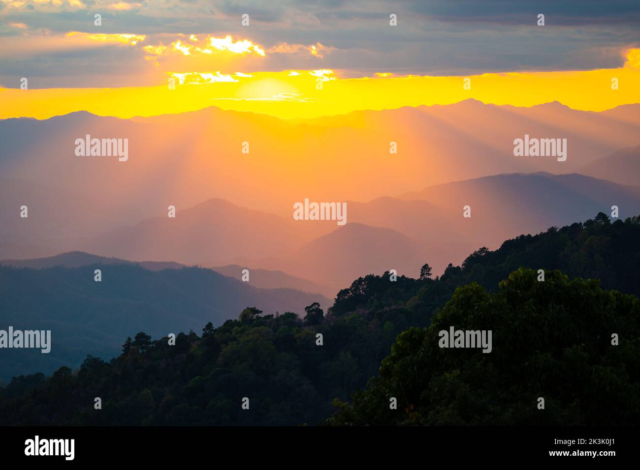 Aerial view of dramatic orange sunlight shining through clouds to blue ...