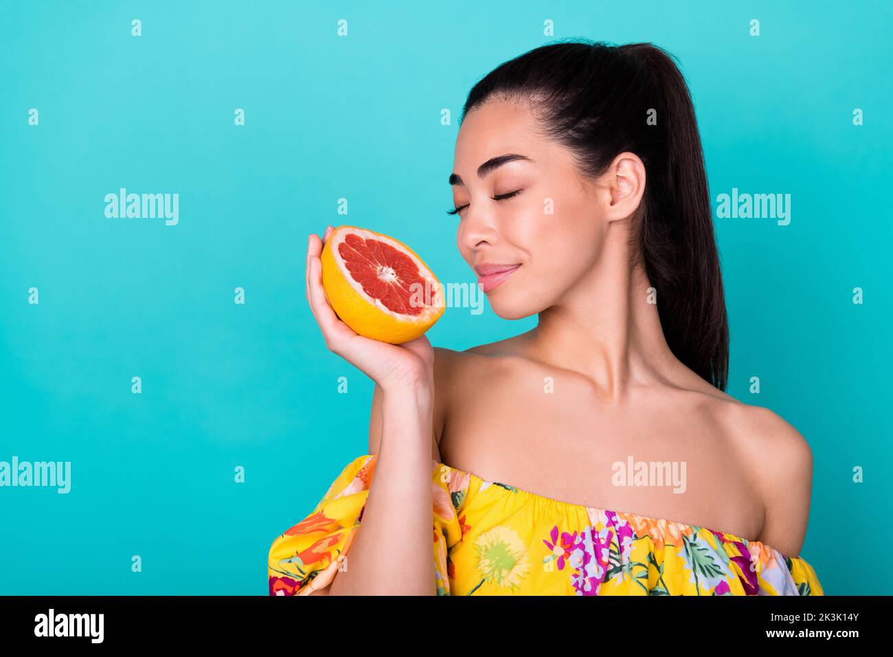 Closeup photo of young japanese pretty girl first time smell holding hands grapefruit isolated ...