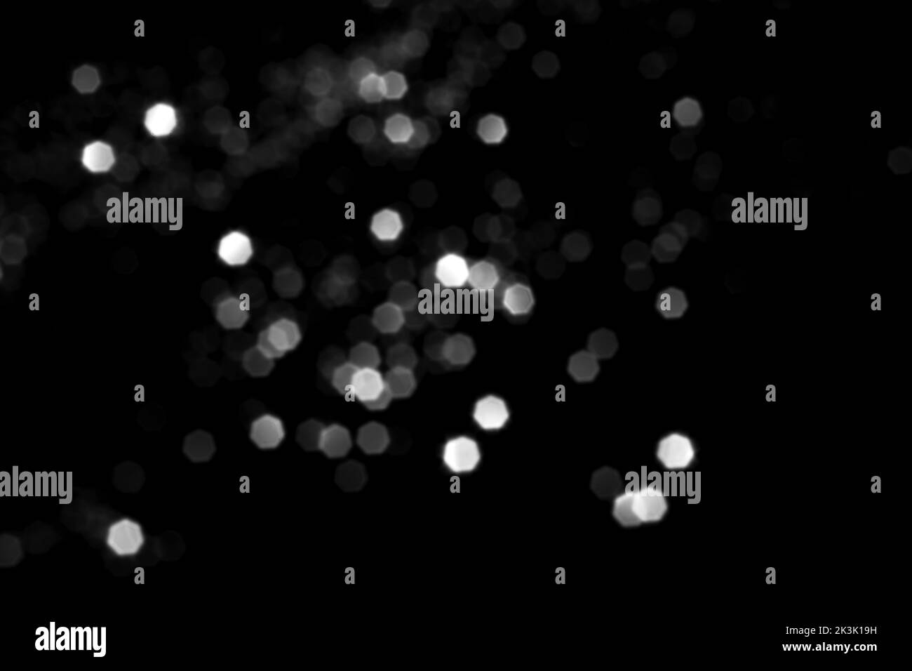 White gray blurred bokeh lights on black background. Glitter sparkle ...