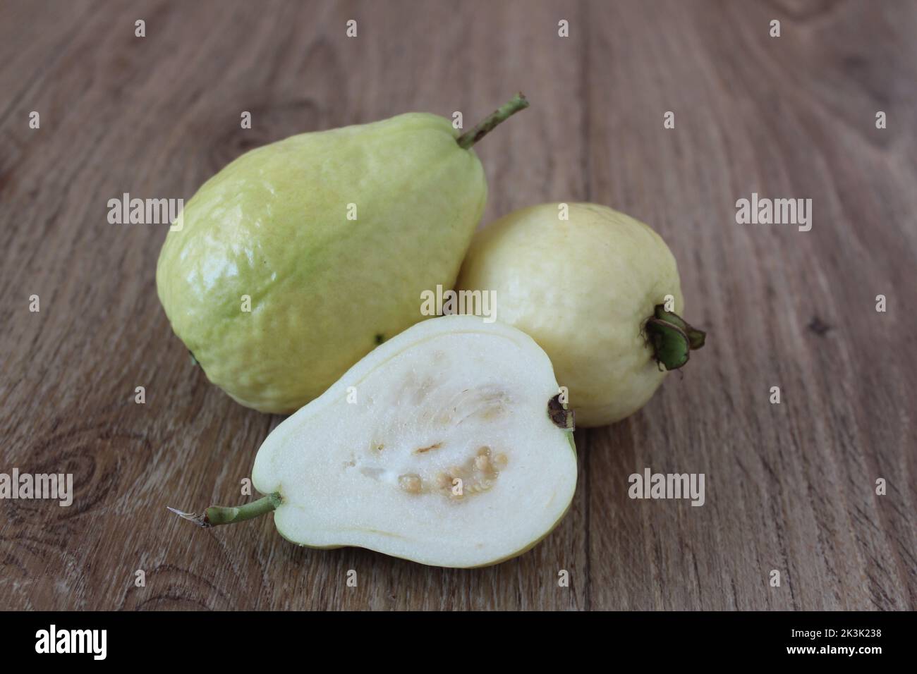 Guava fruit, cut fresh white guava on wooden table. Delicious and juicy ...