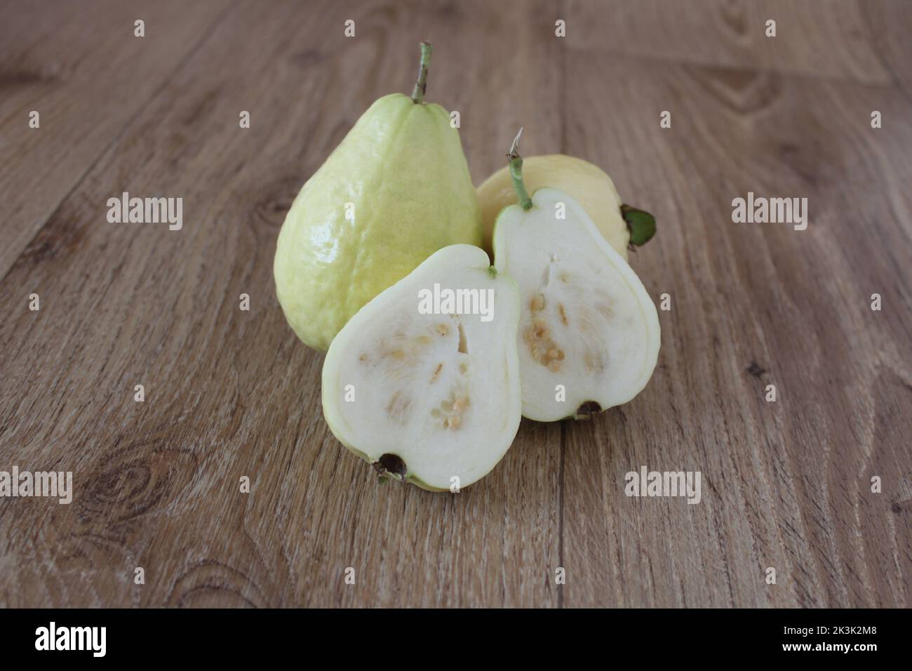 Guava fruit, cut fresh white guava on wooden table. Delicious and juicy ...
