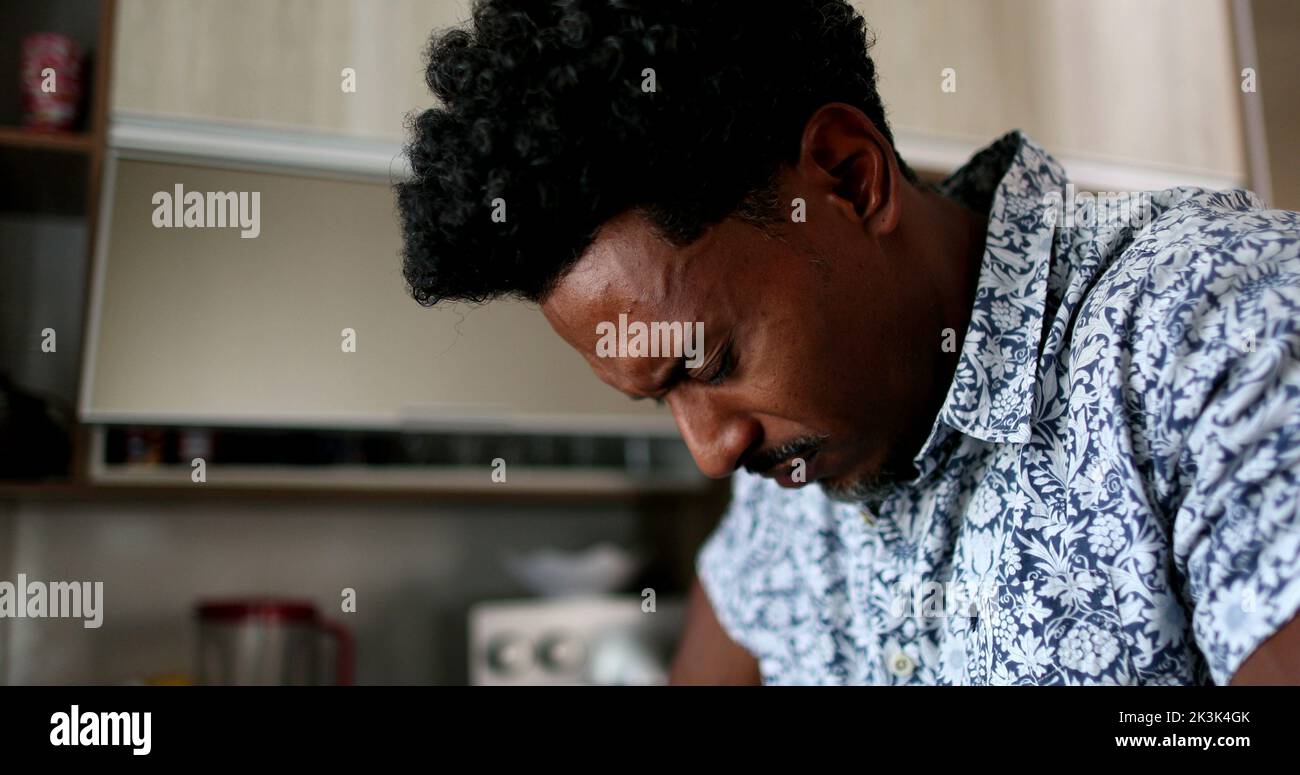Frustrated black African man looking down in mental pain Stock Photo ...