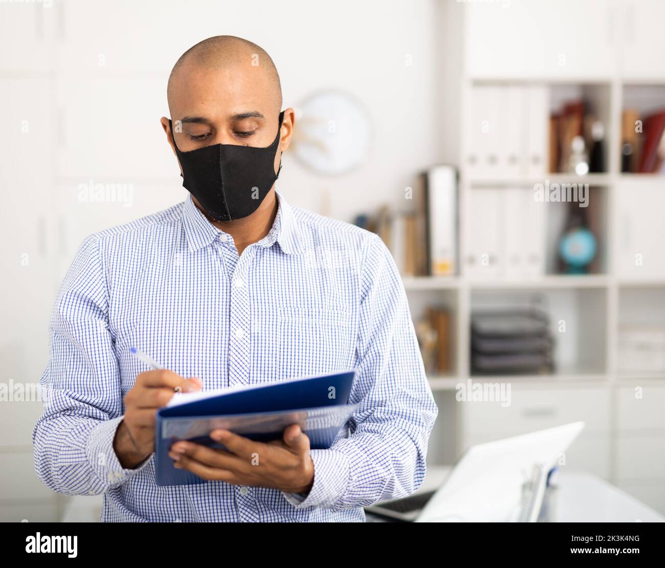 Portrait of manager wearing face mask for prevention while standing at ...