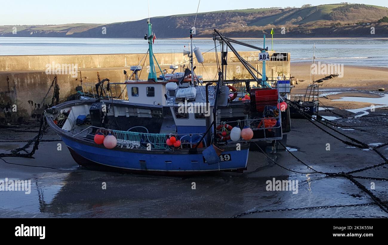 A fishing boat on the seafront in New Quay Harbour with the sea and ...