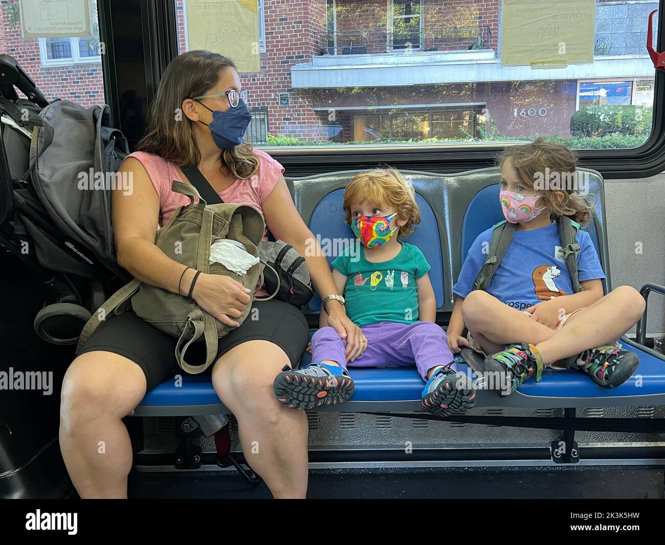 Woman with children all in fasce masks rides a New York City Bus in ...