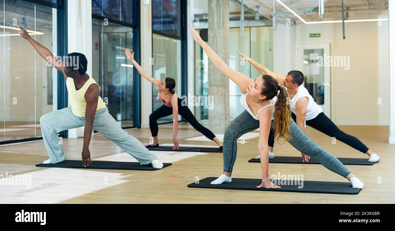Sporty people doing stretching workout during pilates training Stock ...