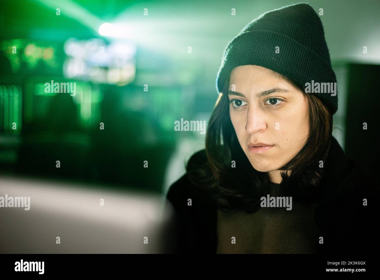 Female hacker working on laptop in dark room Stock Photo - Alamy