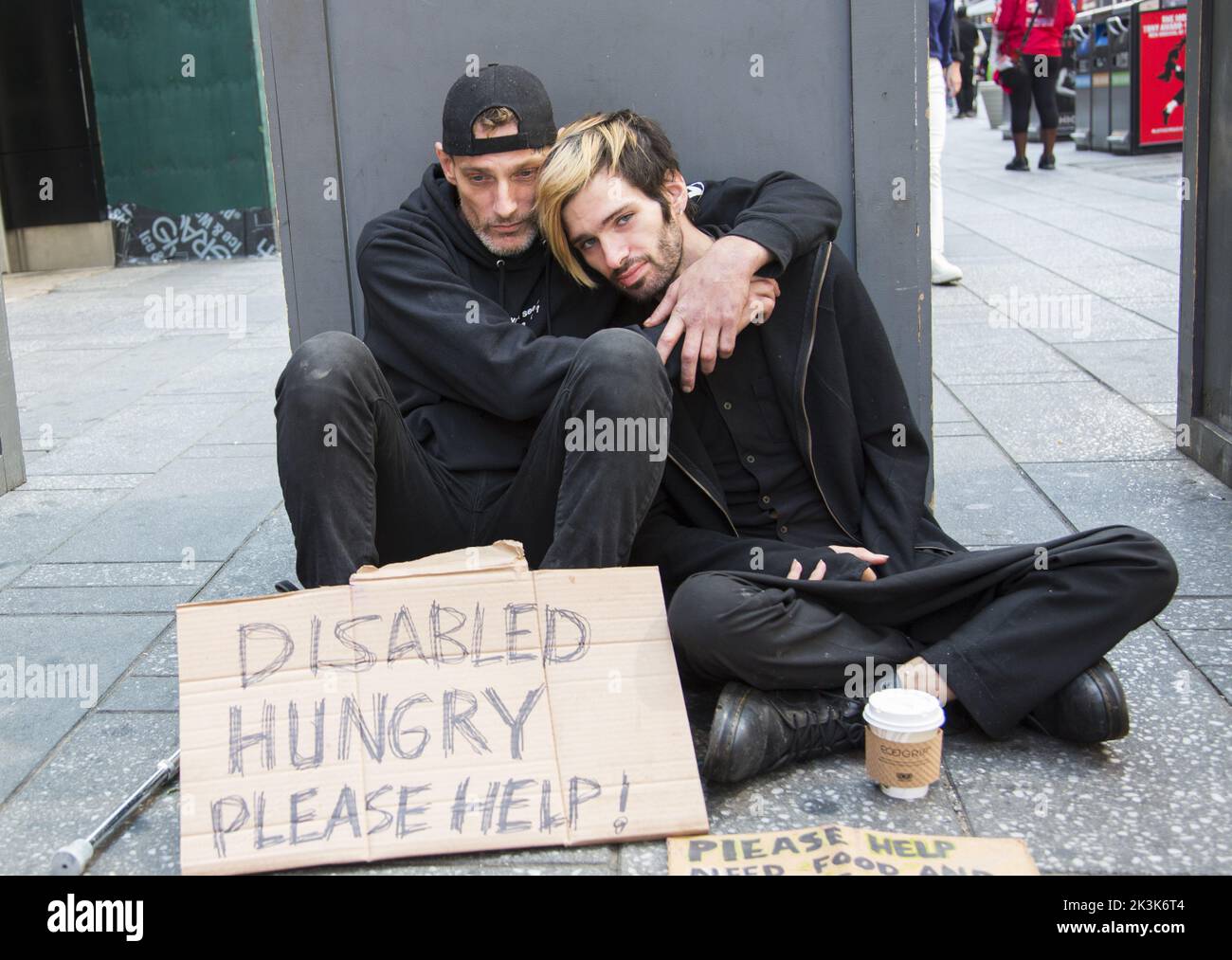 Homeless disabled man with partner ask for help sitting on the sidewalk ...
