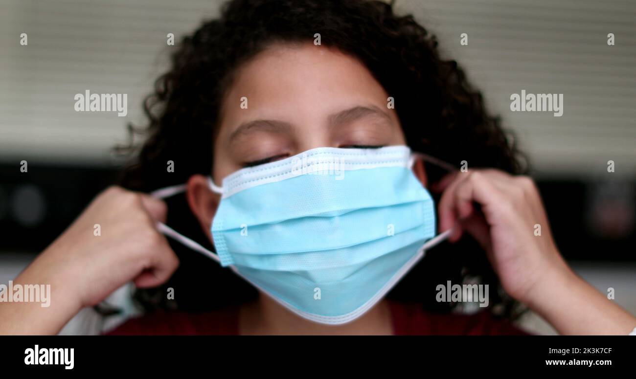 Happy child taking off covid face mask Stock Photo - Alamy