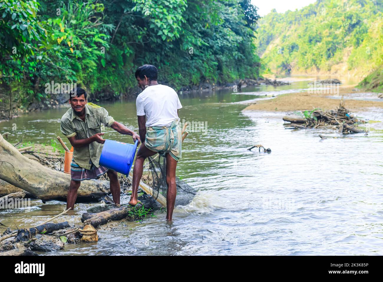 Tribal fishermen catch fish with fishing nets in the creek. Tribals ...
