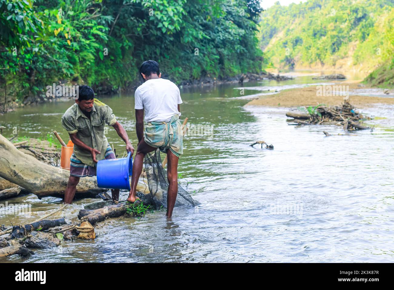 Tribal fishermen catch fish with fishing nets in the creek. Tribals ...