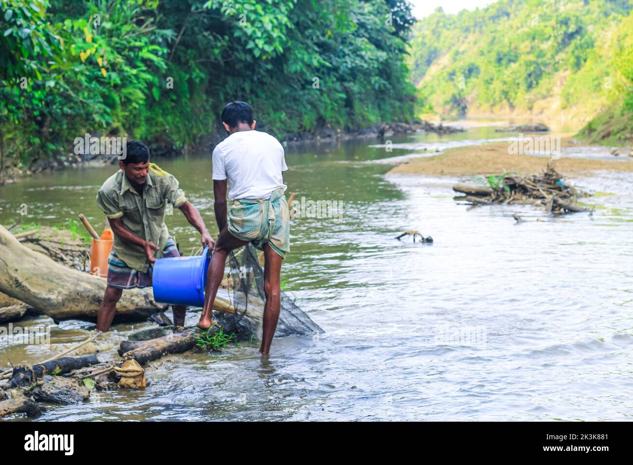 Tribal fishermen catch fish with fishing nets in the creek. Tribals ...
