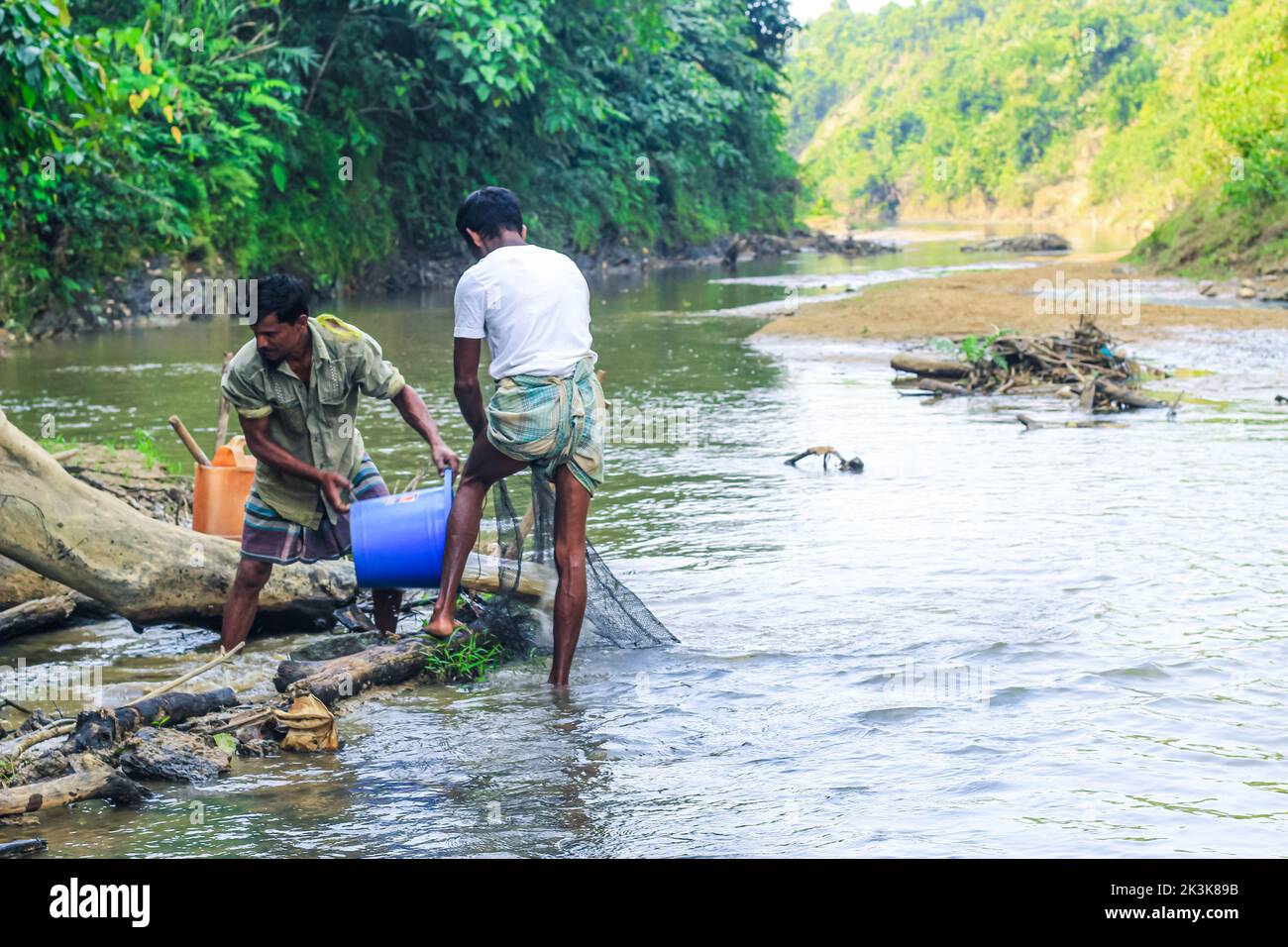 Tribal fishermen catch fish with fishing nets in the creek. Tribals ...