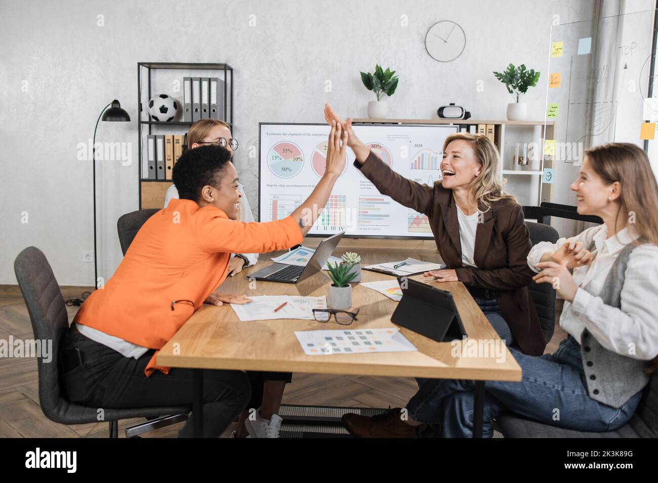 Positive multiracial businesswomen partners giving high five during ...