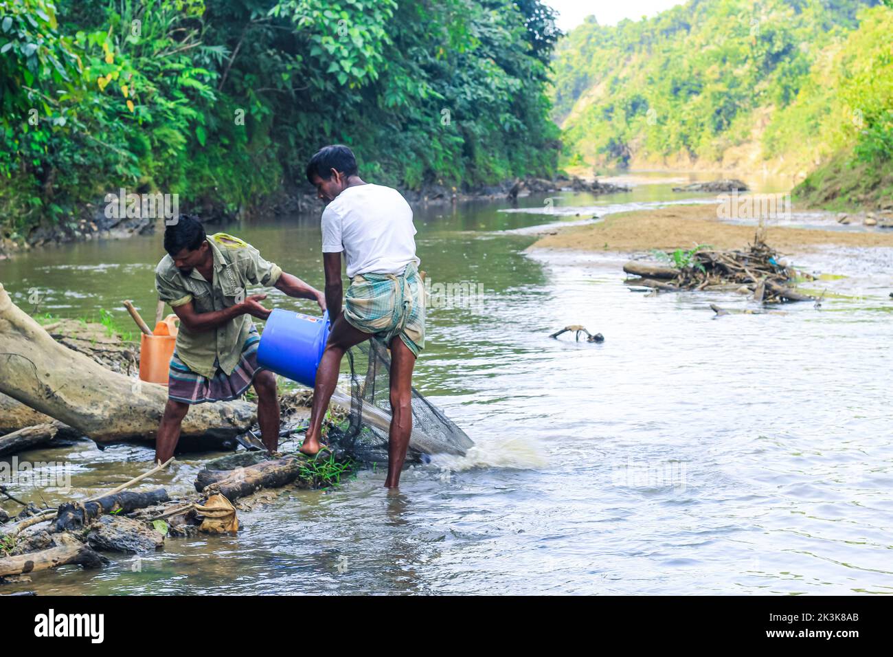 Tribal fishermen catch fish with fishing nets in the creek. Tribals ...