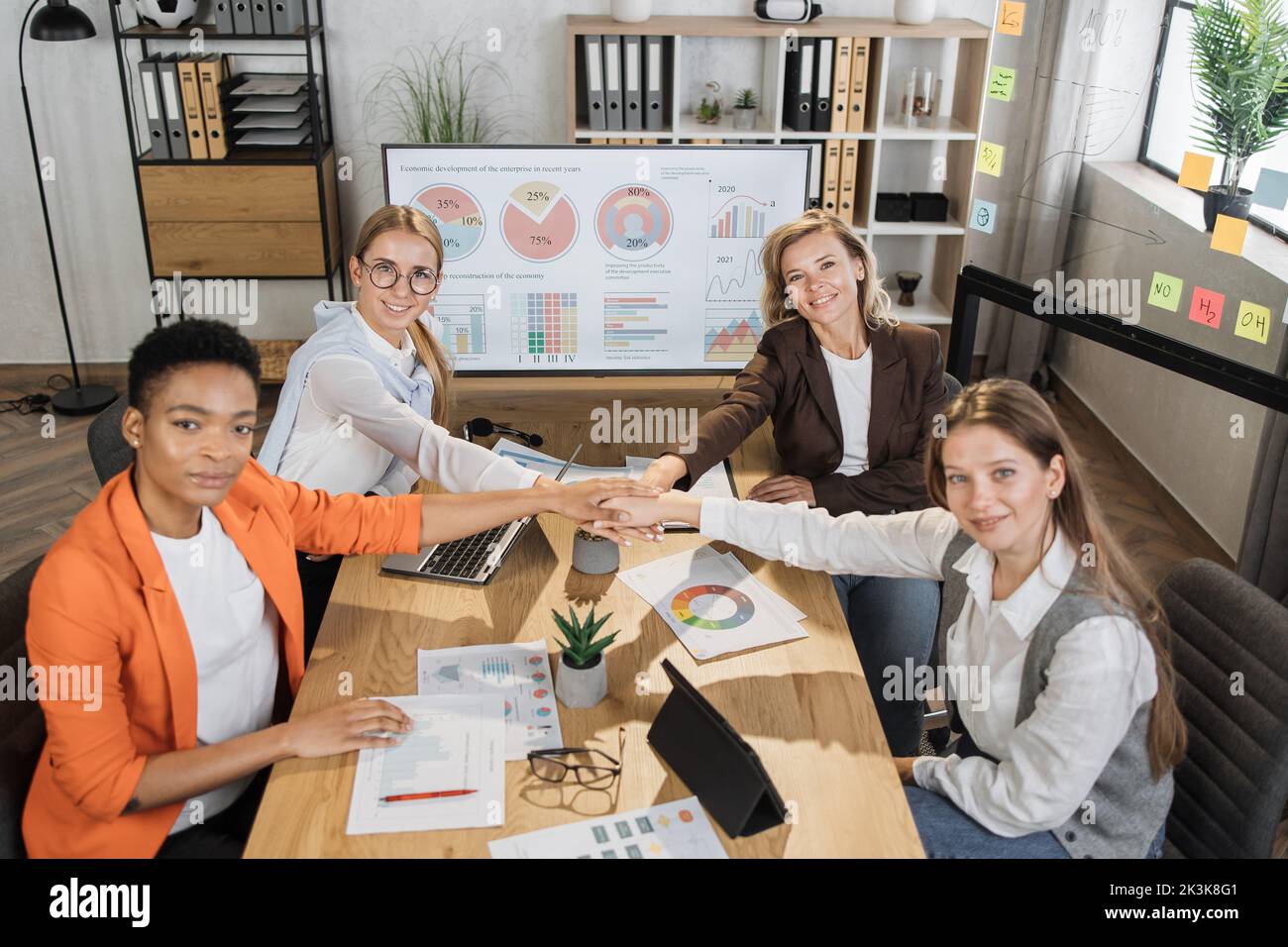 International team of competent female brokers holding their hands ...