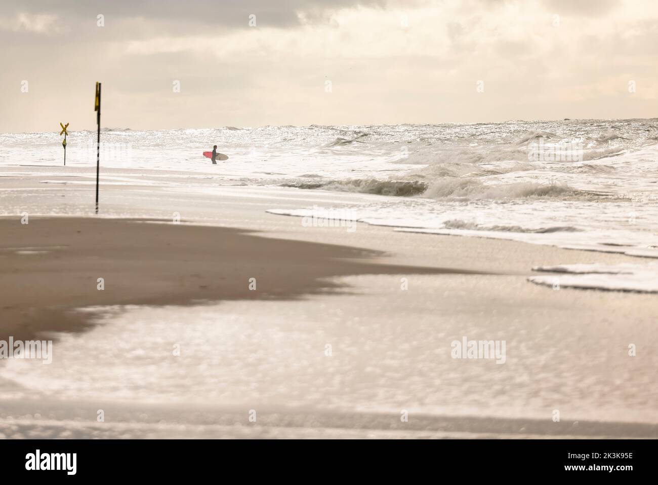 27 September 2022, Schleswig-Holstein, Westerland/Sylt: A surfer stands ...