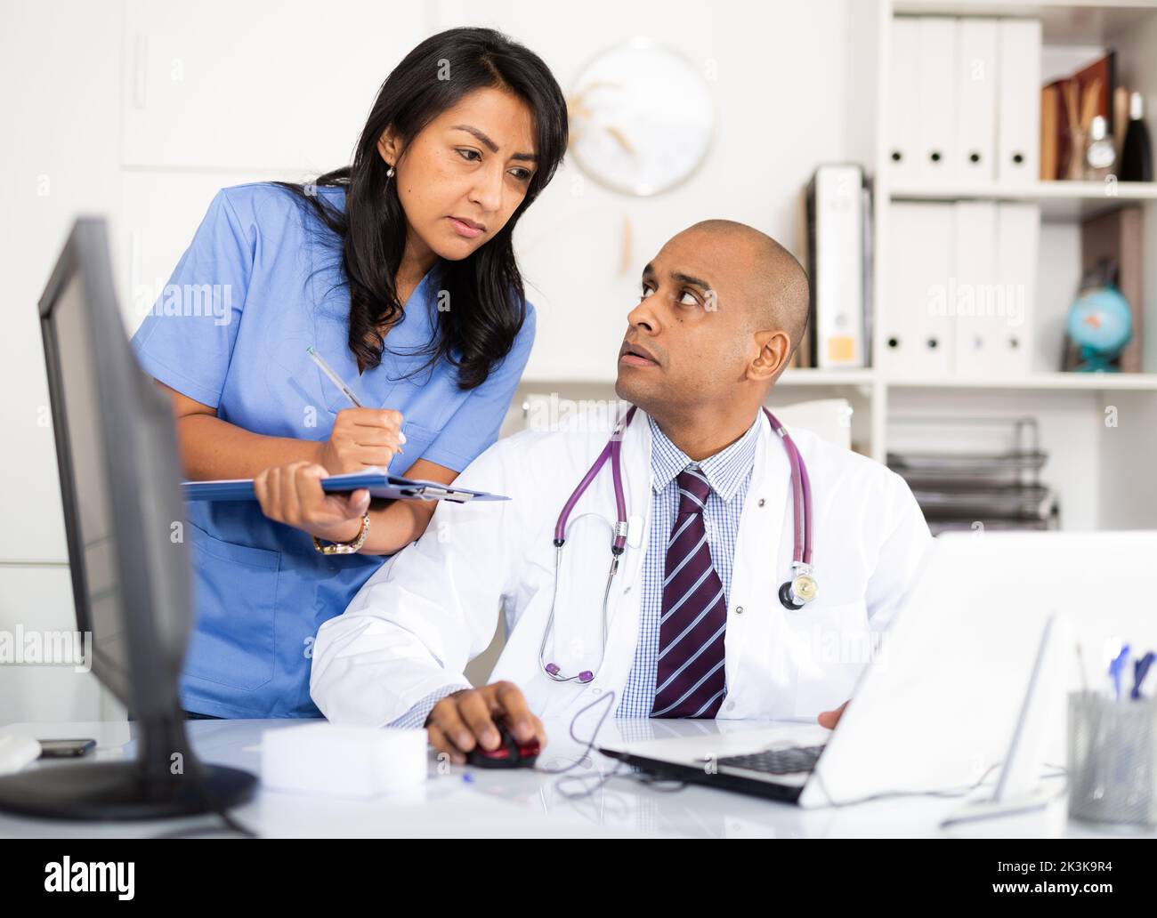 Doctor and nurse check patient data in hospital computer Stock Photo ...