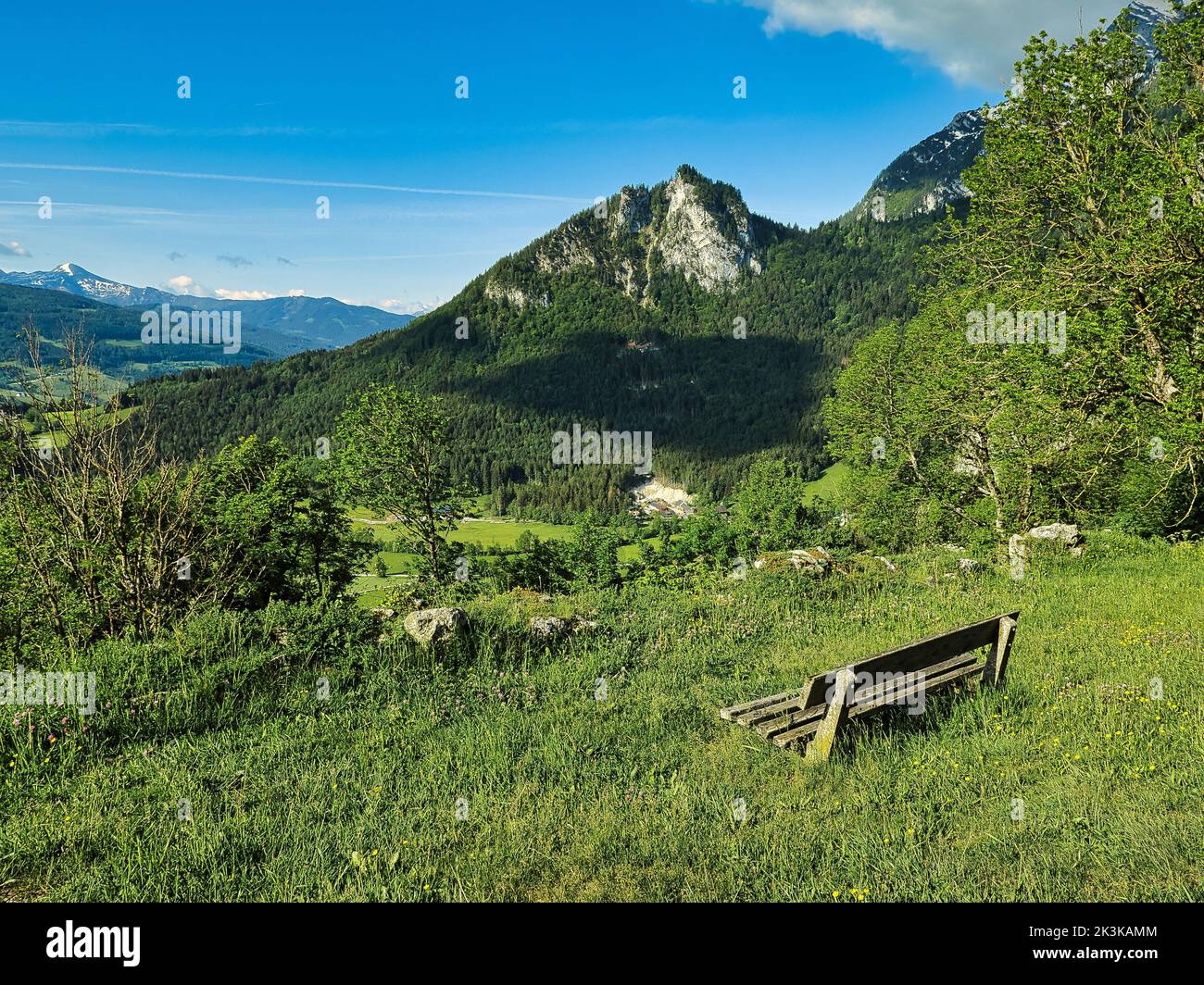 A wooden bench on a green hill looking over the Grimming peak in Purgg ...