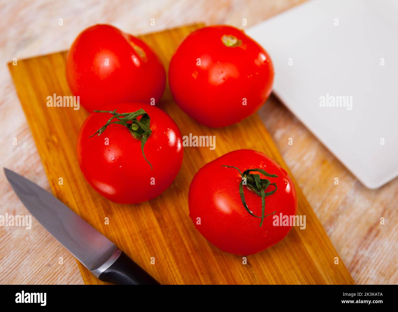 Fresh red tomatoes on wooden cutting board Stock Photo - Alamy