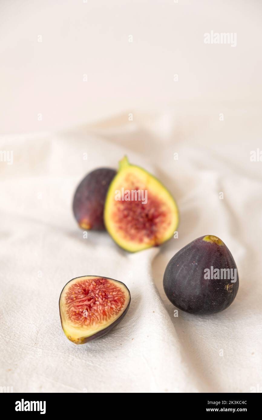 Fresh ripe and sweet figs cut and whole on beige color table cloth ...
