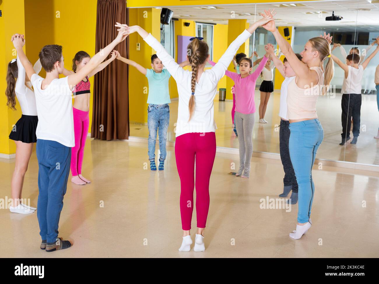Children with teacher holding hands and dancing in dance school Stock ...