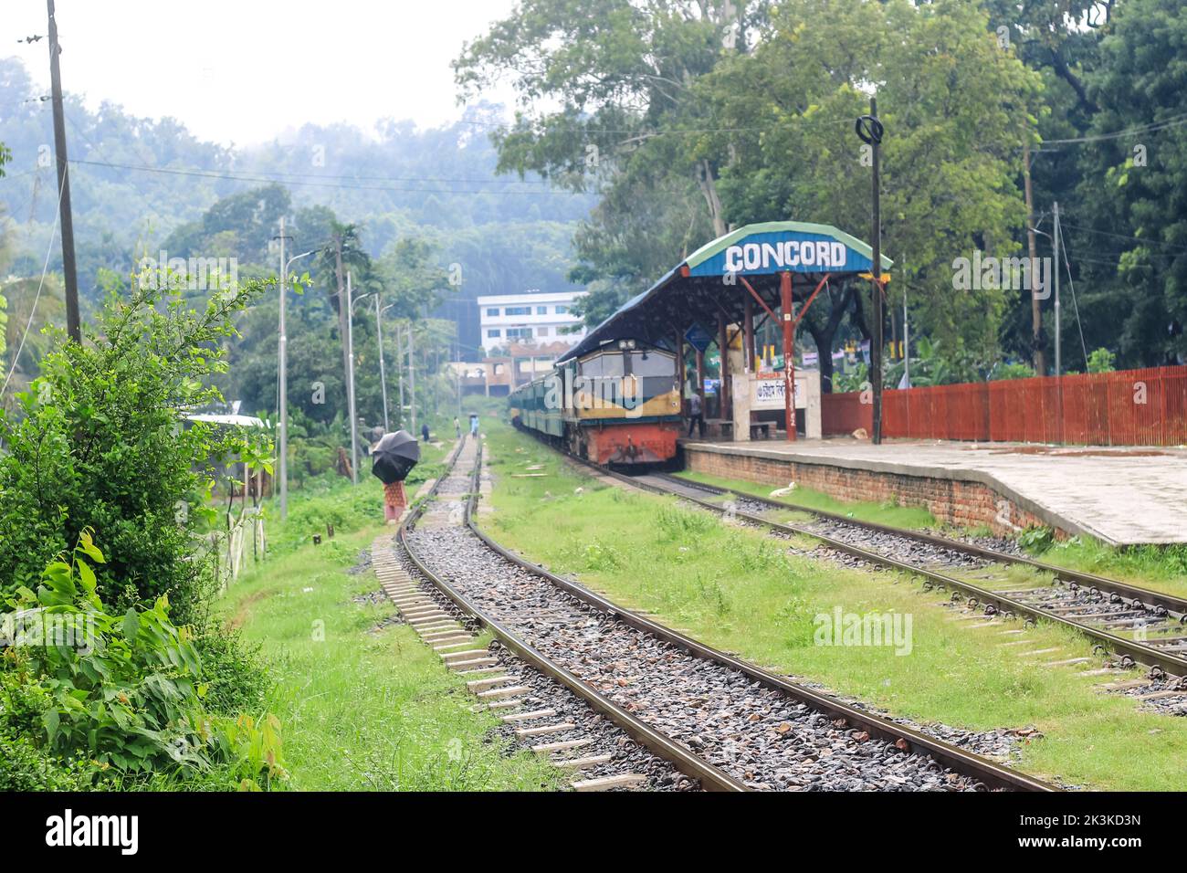 People are waiting in the rain for the train. It is a rainy railway ...
