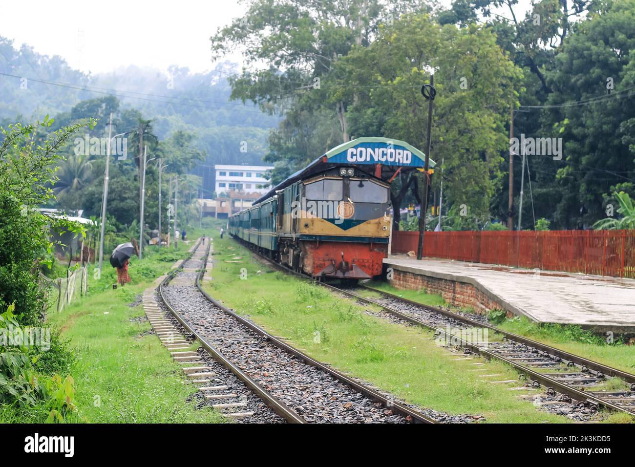 People are waiting in the rain for the train. It is a rainy railway ...