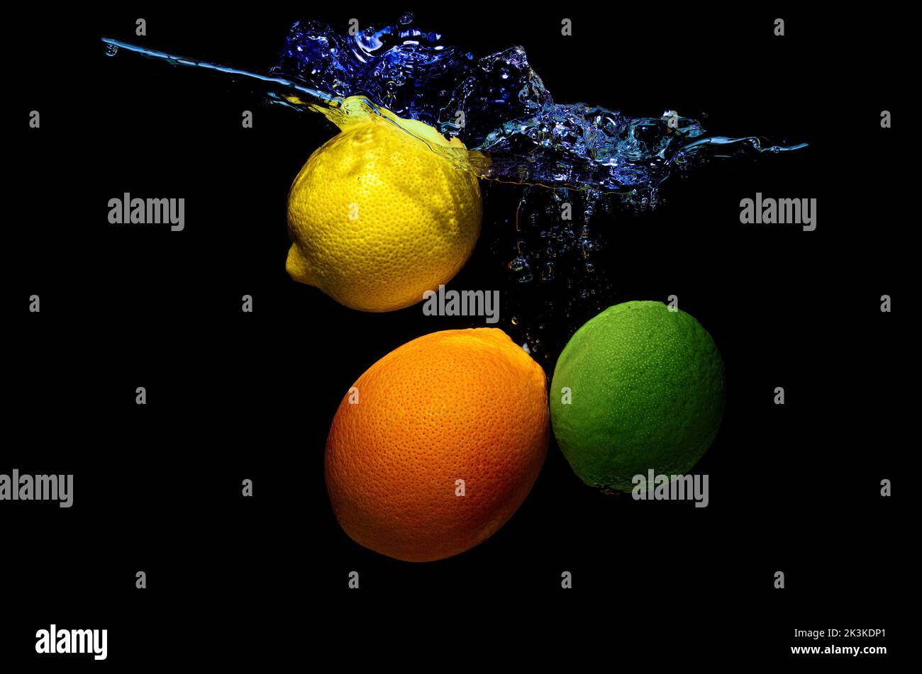 Mix of citrus fruits dropped in water with splashes isolated on black ...